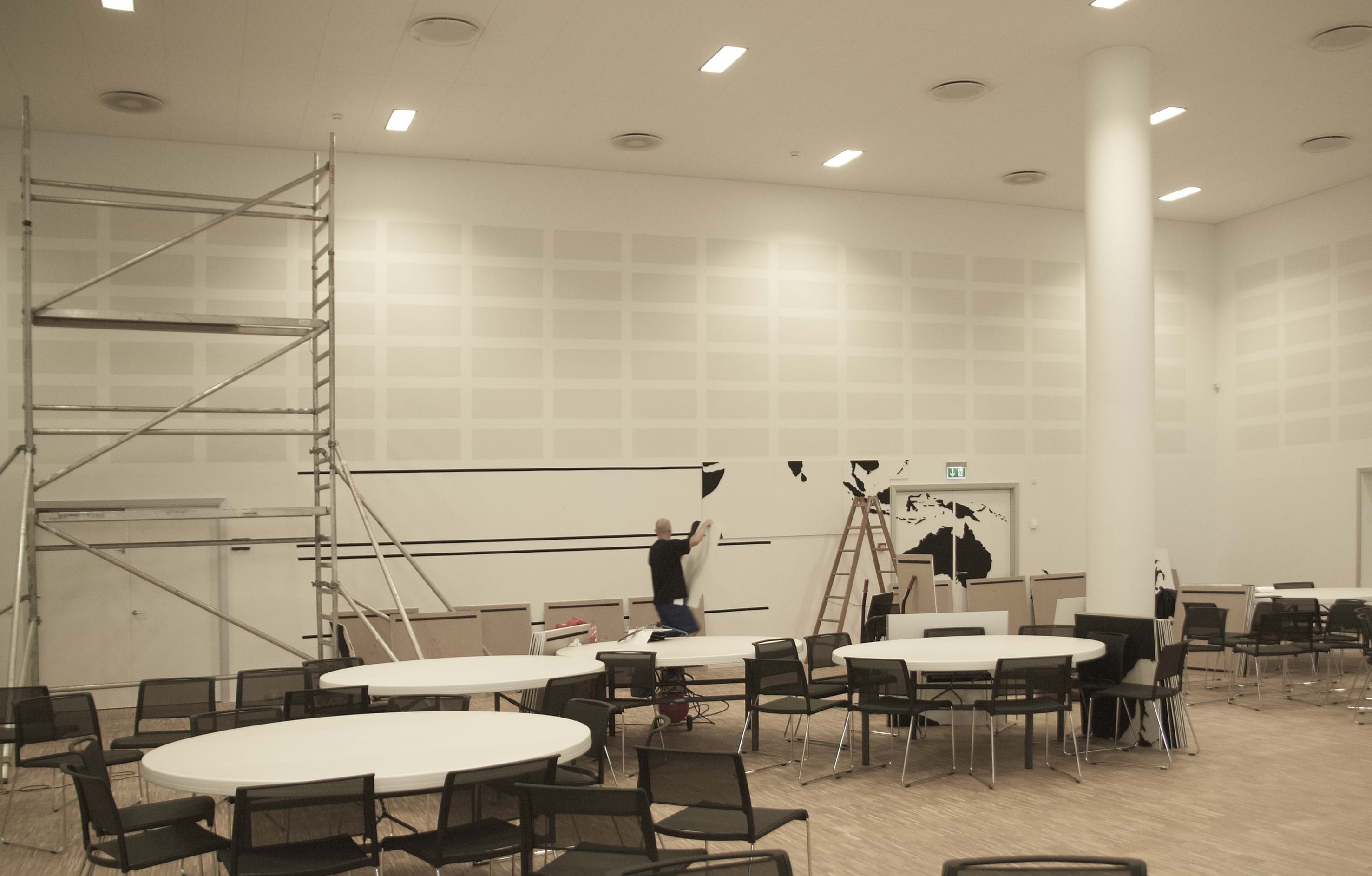 Et stort verdenskort af filt. Flot installation i konference rum